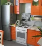 Dapur kecil dengan perabot oren dan peti sejuk