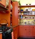 Mørke oransje møbler på smalt kjøkken