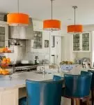 Oransje lysekroner på kjøkkenet med lyse stoler