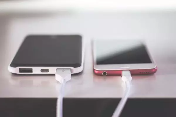 Смартфони, до яких під'єднані USB-кабелі