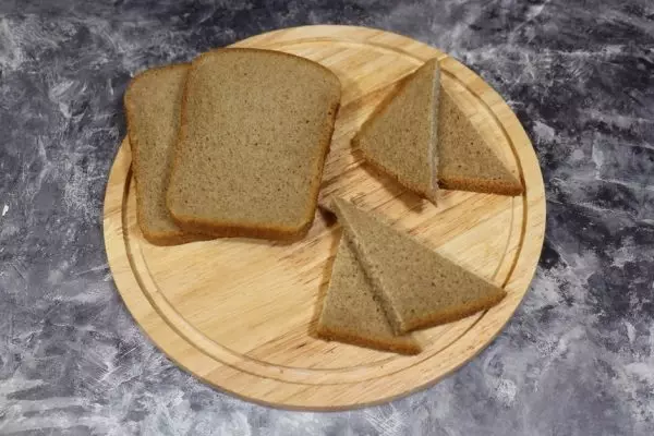 Scheiben von Roggenbrot auf einem runden Schneidebrett aus Holz