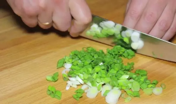 Grüner Bogenschneiden auf einem hölzernen Schneidebrett