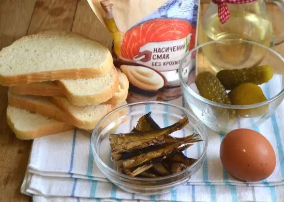 Produkte zum Kochen von Sandwiches mit Sprotten, Ei und eingelegten Gurken auf dem Tisch