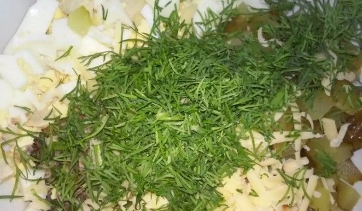 Ingredienti per insalata di pesce con formaggio solido, cetriolo salato, uova e aneto in una ciotola