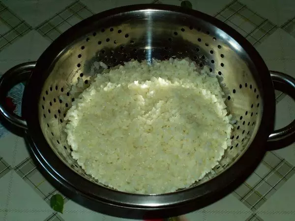 Kokt ris i metallisk kolander på bordet