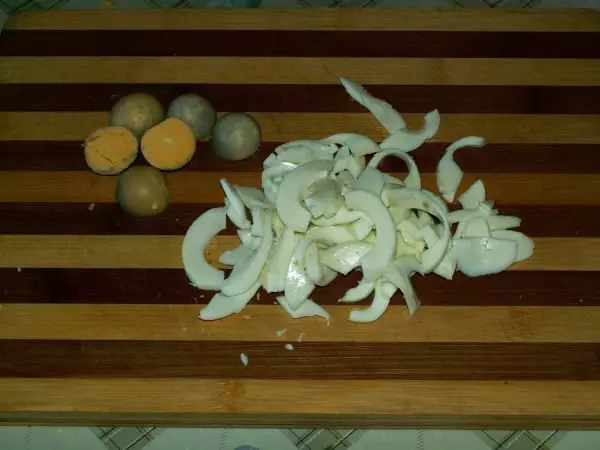 Hiniwang piraso pinakuluang itlog at yolks sa isang cutting board