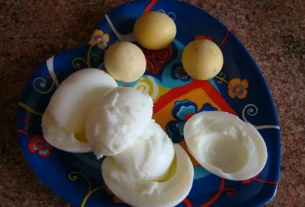 Auf Proteinen erfasst und Eigelb gekochte Eier auf einem Teller in Form eines Herzens