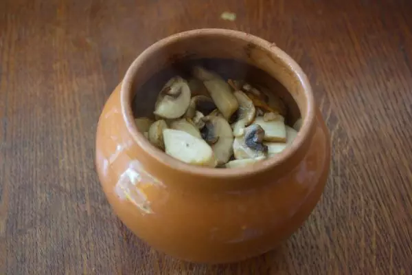 Irisan Chartignons panggang di dalam periuk dengan kosong untuk daging rebus dengan sayur-sayuran