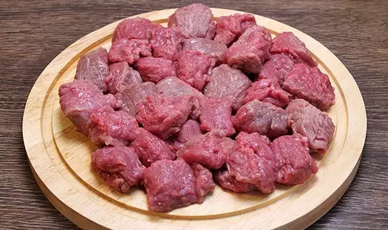 Bir kesme tahtası üzerinde dilimlenmiş çiğ sığır eti