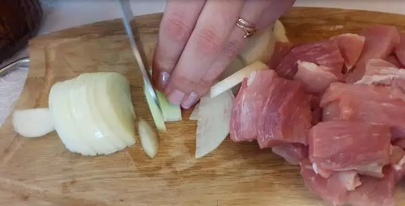 生肉片和切碎的洋葱在切板