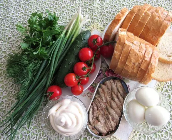 Products for the preparation of festive sandwiches with sprats and vegetables on the table