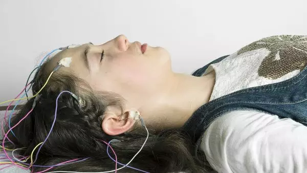 หญิงสาวนอนหลับด้วยเซ็นเซอร์ EEG ติดตามการทำงานของสมอง