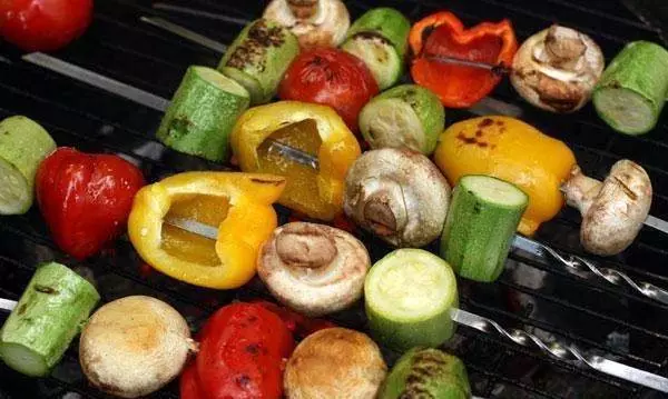 Skewers of fresh vegetables and champignons on the grill