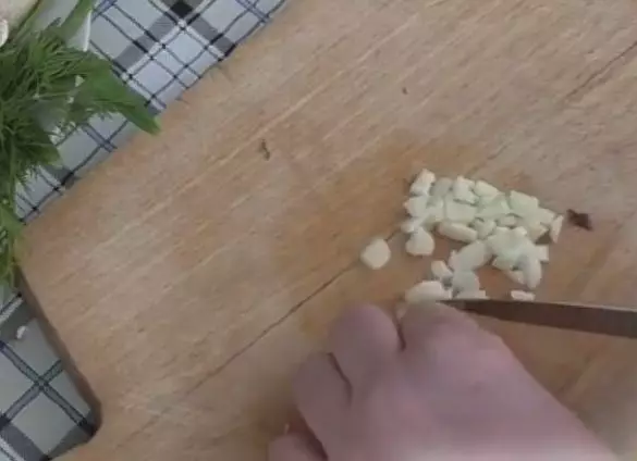Grinding garlic knife on a cutting board