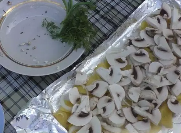 Potatoes, onions and champignons on a foil for baking