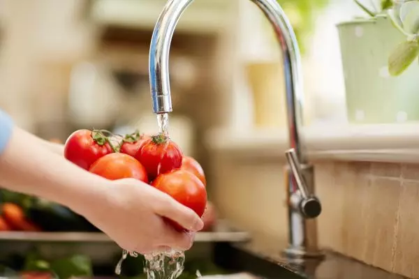 Vaske tomater under rennende vann