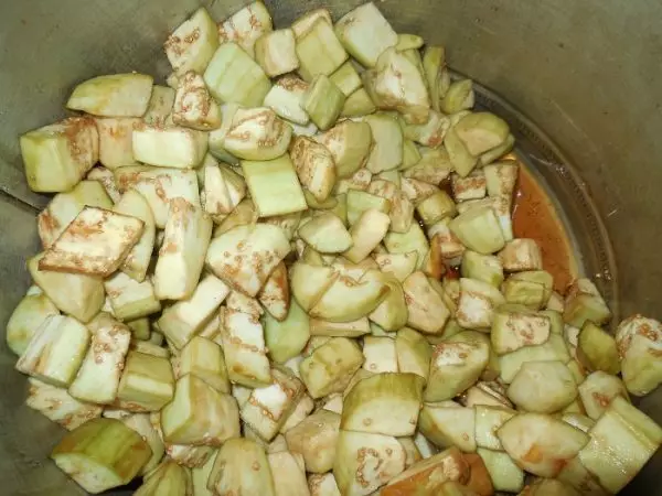 Hakket eggplant kuber i en stor kasserolle