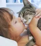 Bebek bir kediyi öper