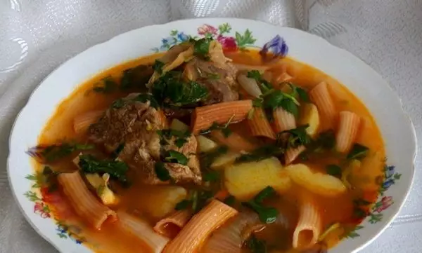 Goveja juha s testeninami, krompir in Cilantro v obroči plošči na mizi