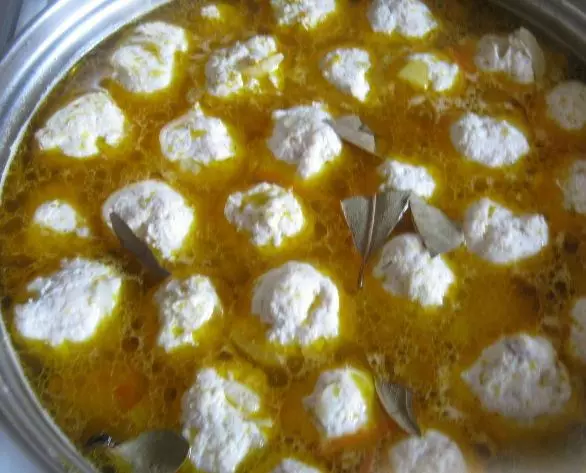 Sopa con albóndigas, tostador vegetal y hoja de laurel en una cacerola grande