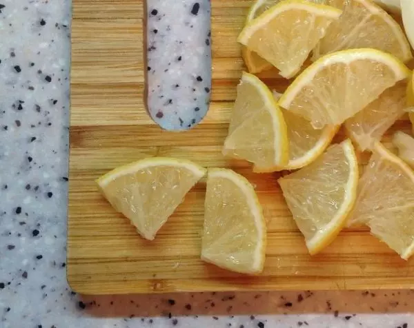 Rebanadas a piezas de limón en una tabla de cortar
