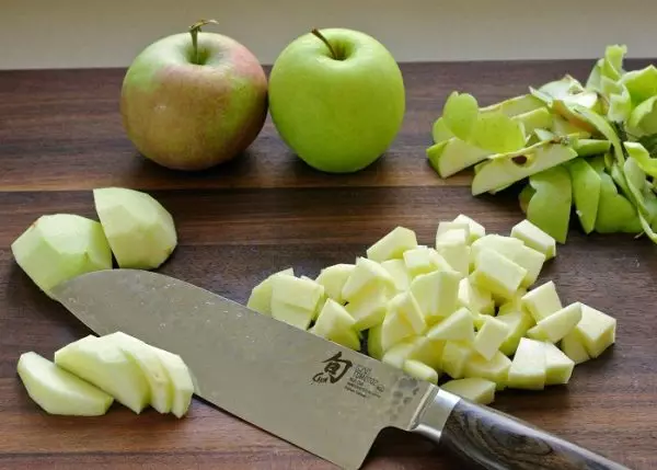 Dos manzanas enteras y puñado de rebanadas de manzanas.