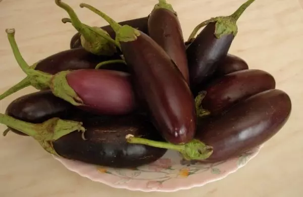 Ychydig o eggplantau ffres ar blât