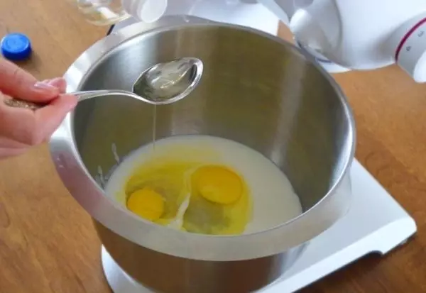 Zure room en rauwe eieren in een metalen mixerkom