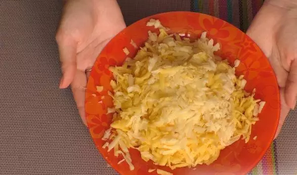Kovrčavi sirovi krumpir u crvenom spremniku