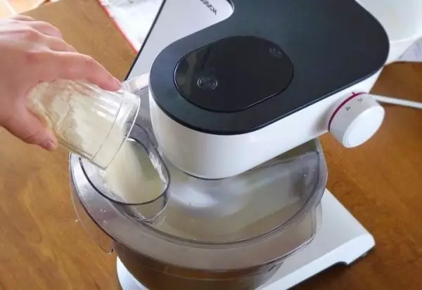 Lägga till mjöl i en mixerskål med en äggkassblandning
