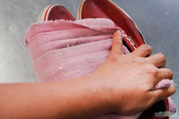 Estiramiento de zapatos con la ayuda de una toalla vieja.