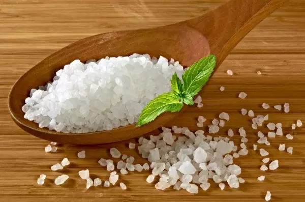 نمک در یک قاشق و روی میز