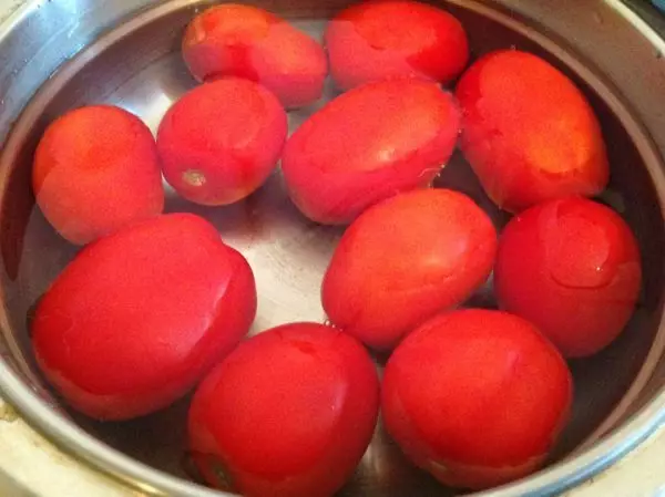 گوجه فرنگی های تازه در یک ظرف بزرگ با آب