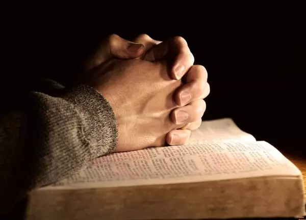 माणूस बायबलवर प्रार्थना करतो