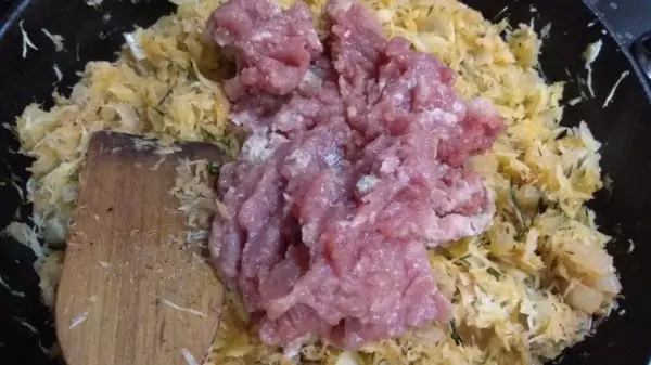 Rå kød hakket kød i en stegepande med udskåret kål