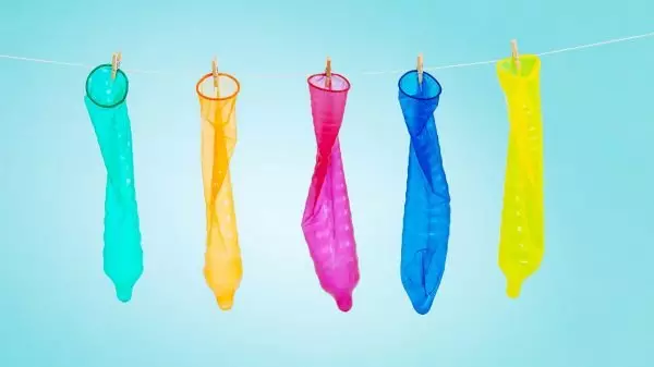 Flerfarvede kondomer hænger på rebet