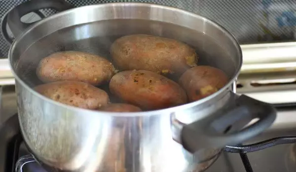 Mga krudo nga patatas sa usa ka saucepan nga adunay tubig sa plato