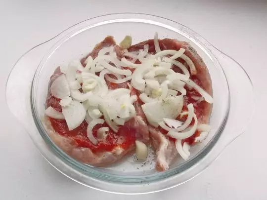 Kött med ketchup och semiringlök i glasbehållare