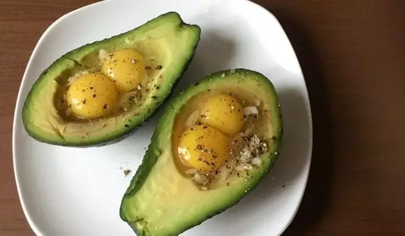 Helften avocado met vullen van eieren op een bord