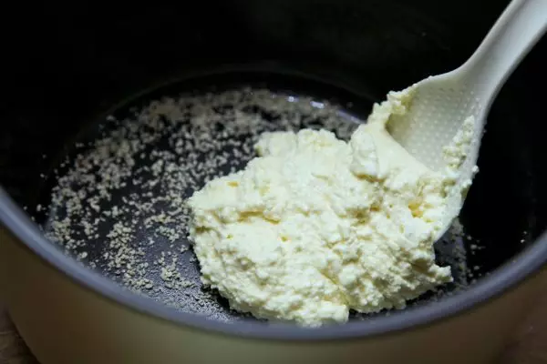 Curd mass in a round form for baking, sprinkled with breadcrumbs