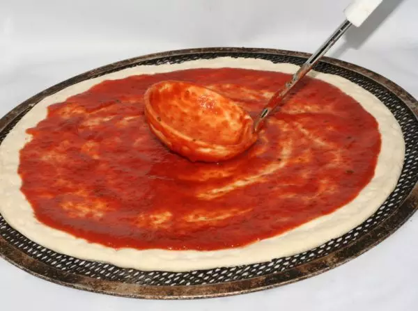 Toes pizza yn iro saws tomato