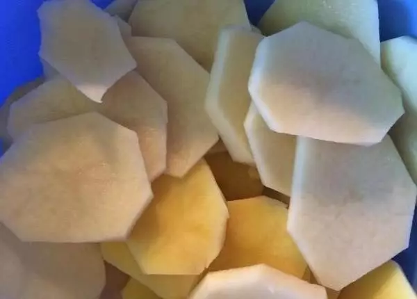 Нарізаний тонкими пластинами сиру картоплю