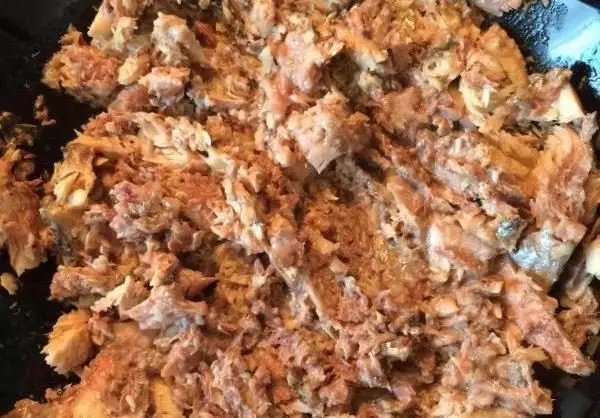 Vorming van de vulcake met aardappelen en vis in de vorm voor het bakken