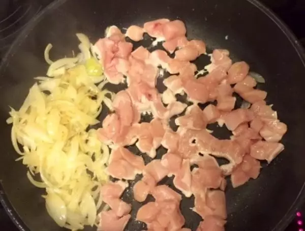Kippenfilet en uien op een koekenpan
