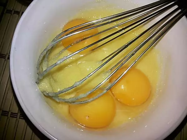 Telur dengan pasir gula dalam mangkuk dan pukul besi