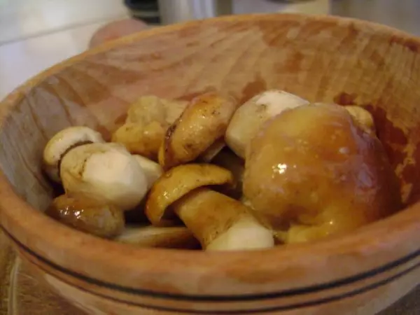 Frozen mushrooms sa wooden bowl.