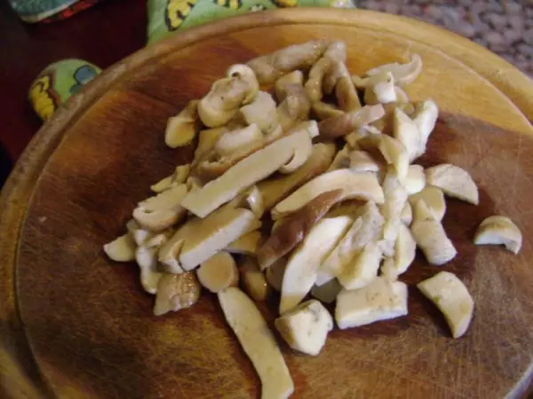 Kawałki gotowanych grzybów na drewnianej desce