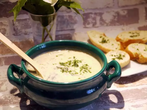 Soupe au fromage et aux champignons dans une tablette sur la table