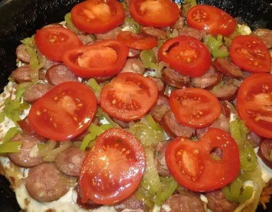 Formación de pizza de patata en una sartén.