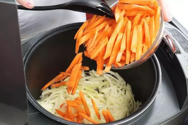 Løg og gulerødder i en skål med multicookers
